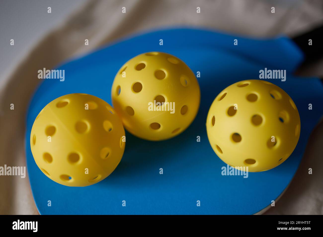Three perforated balls for pickleball on rackets Stock Photo - Alamy
