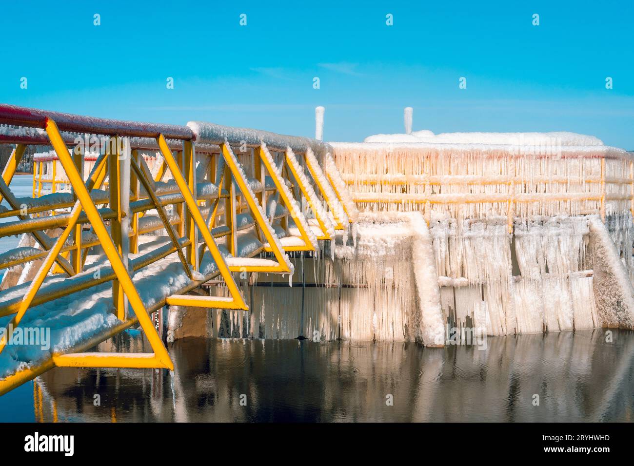 Ice covered metal construction of a small dam Stock Photo - Alamy