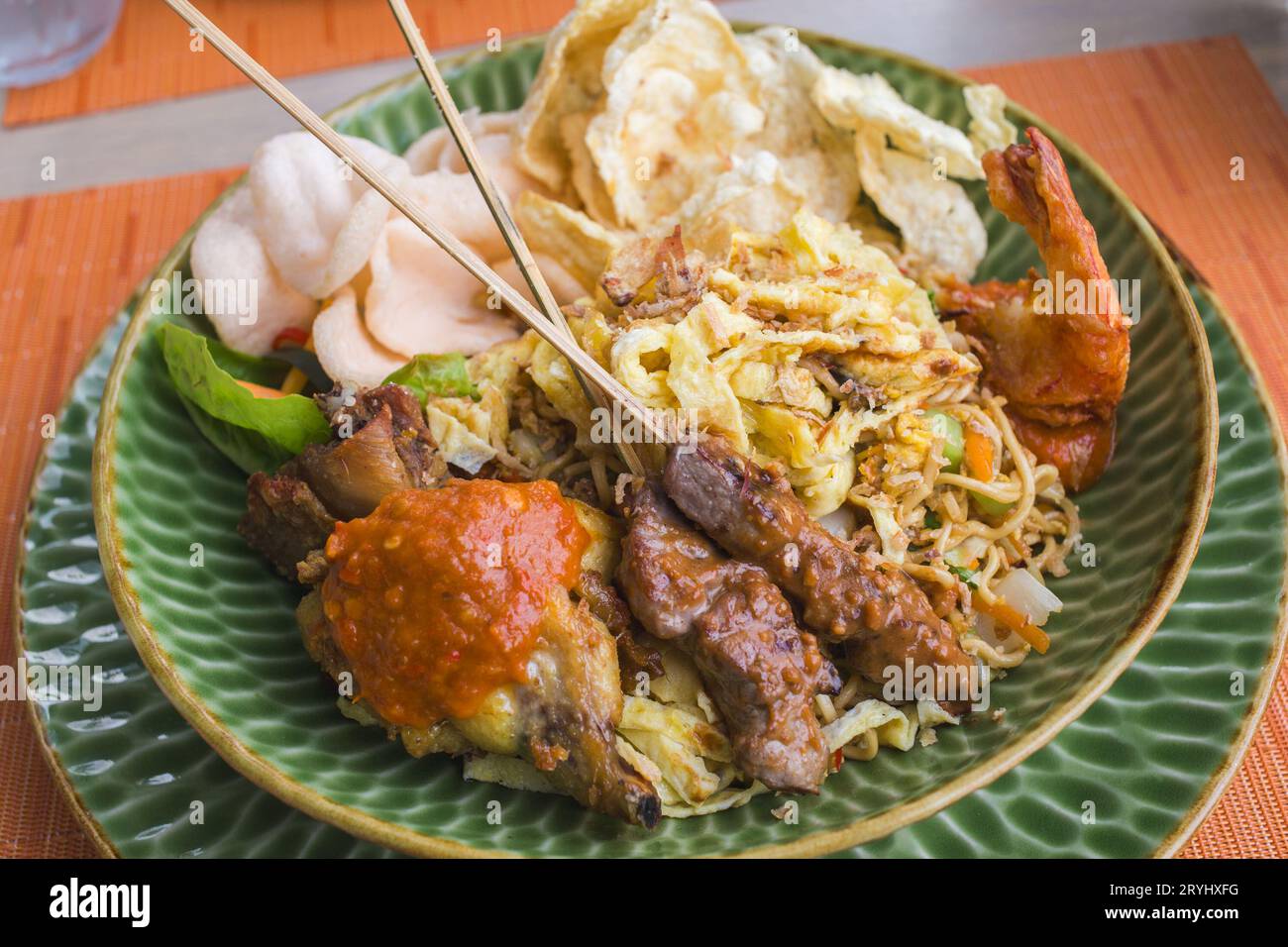A typical dish in Bali with noodles, vegetables, prawn crackers and ...