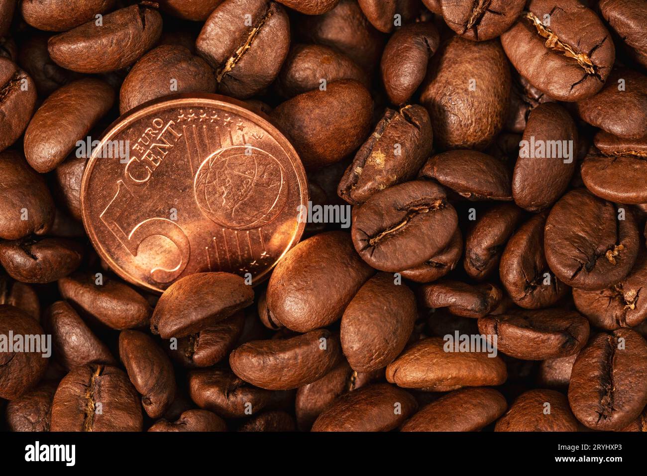 Roasted coffee beans and one five euro cent coin close-up Stock Photo ...
