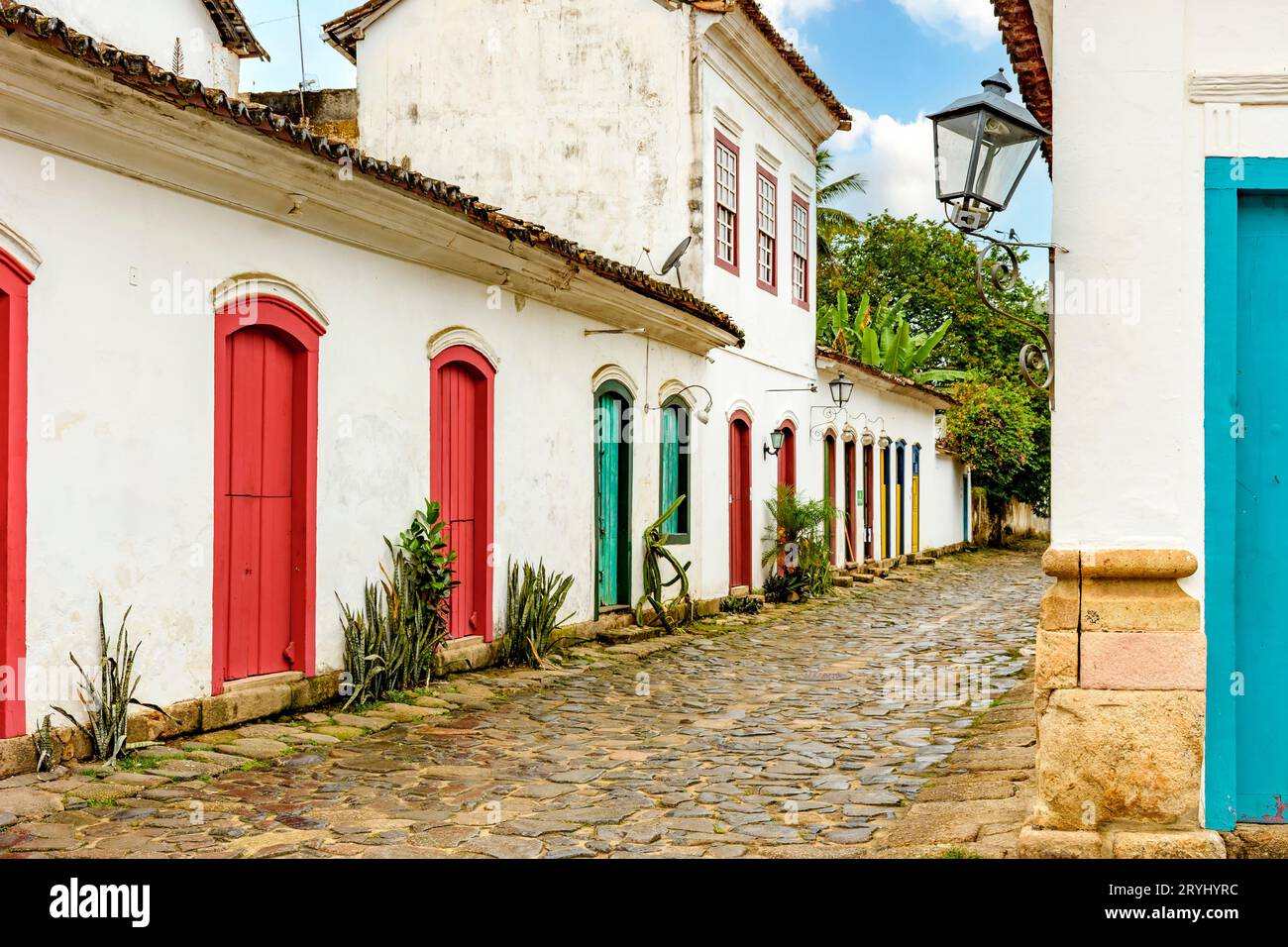 Street with cobblestone pavement and facades of old colonial houses ...