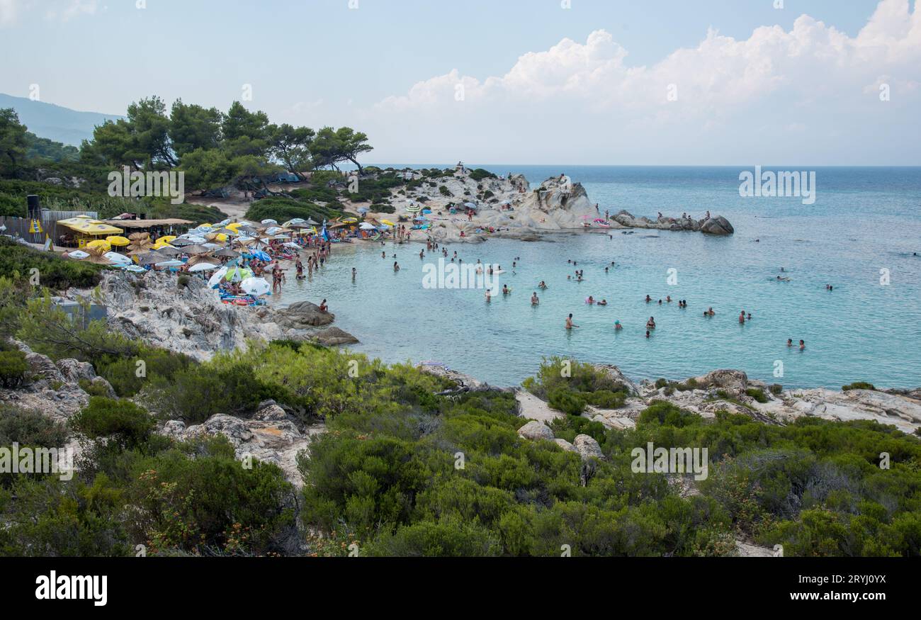 People swimming and sunbathing at kavourotripes beach in Sithonia ...