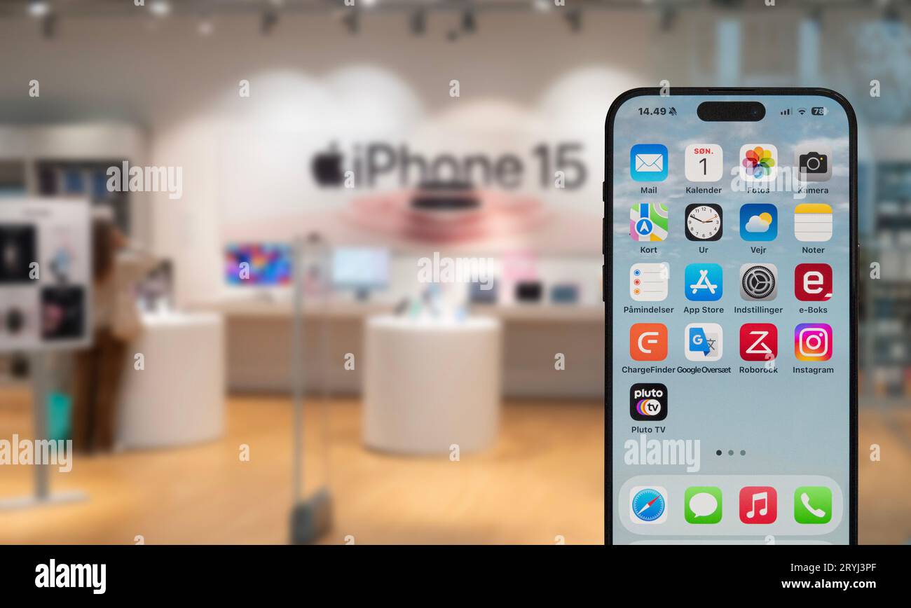 iPhone 15 on display in a store selling Apple products. Blurred shop in ...