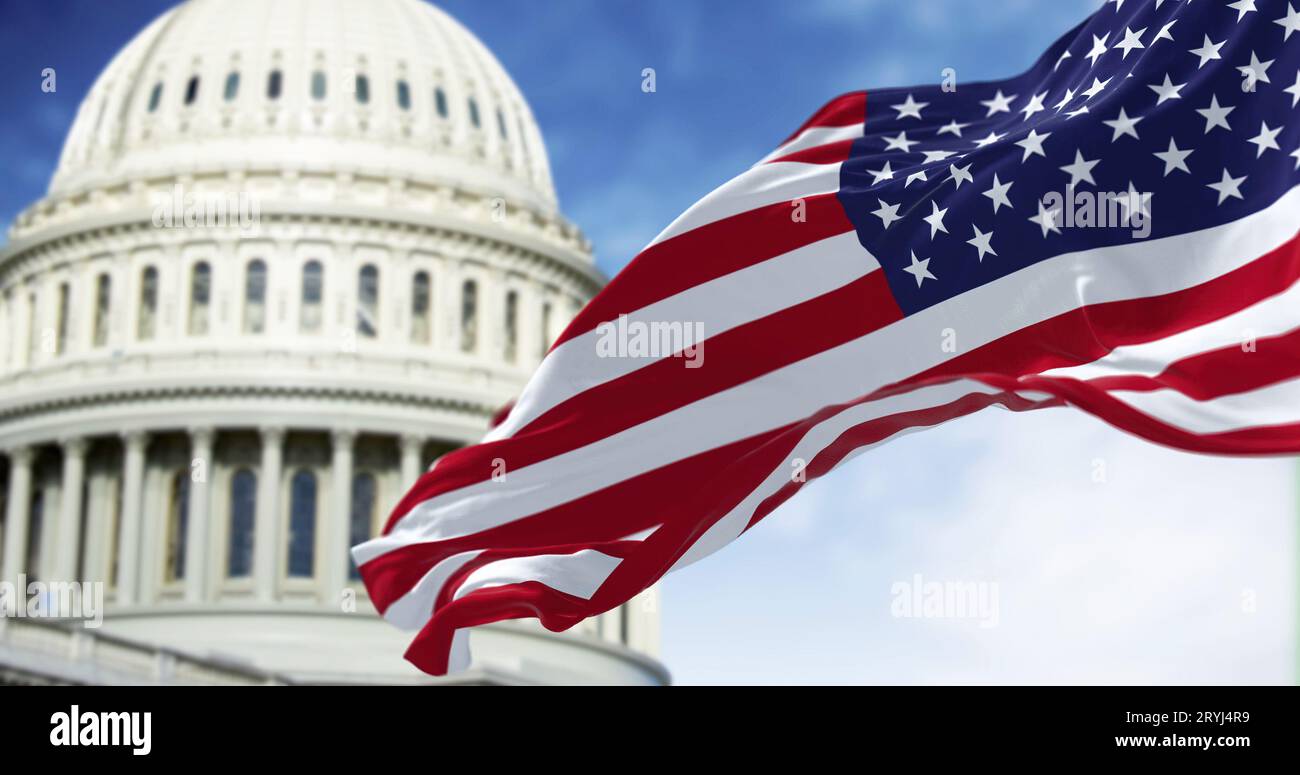 Flag of the United States waving with the American Capitol blurred in ...