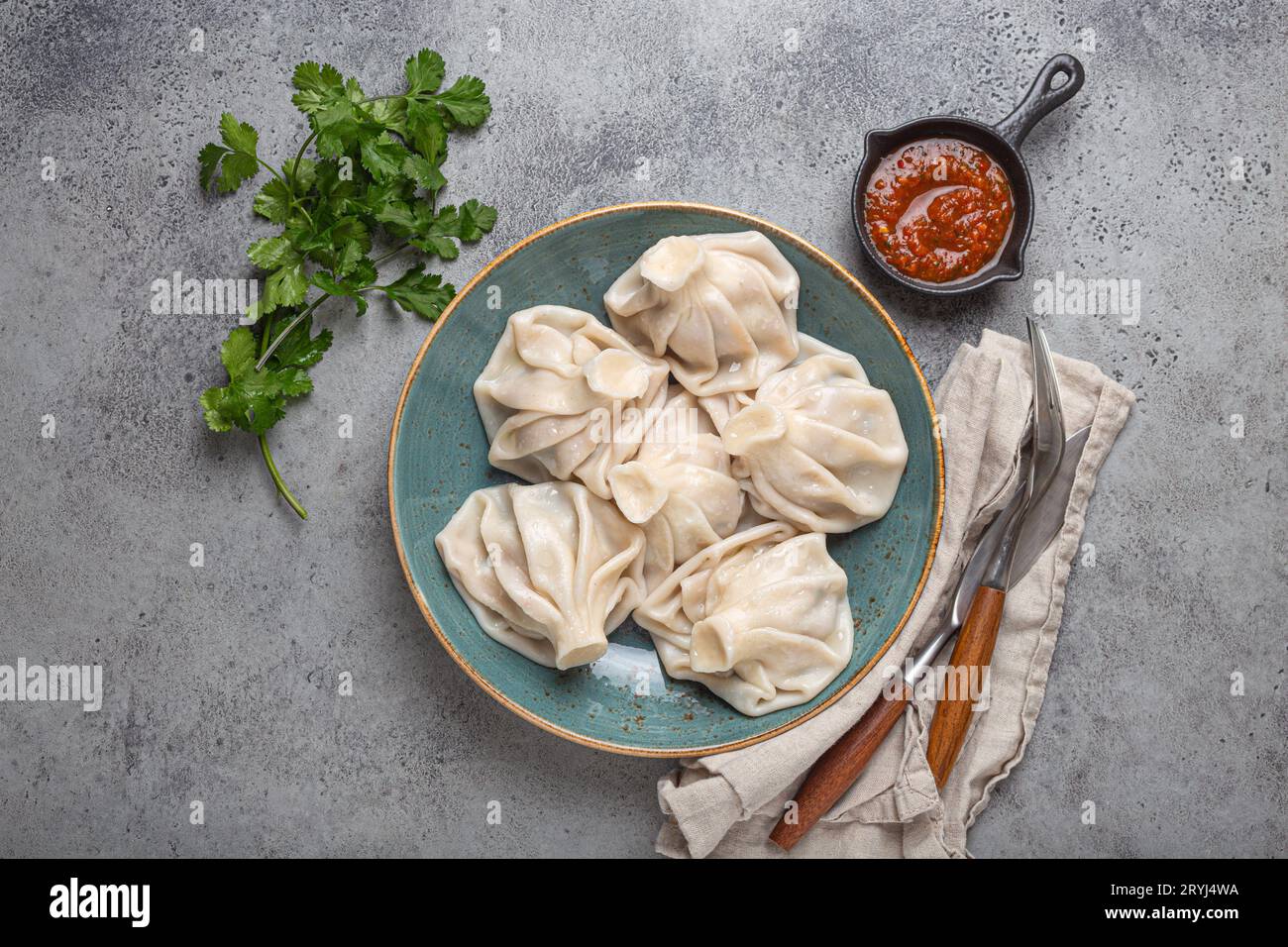 Georgian dumplings Khinkali on plate with red tomato sauce and fresh ...