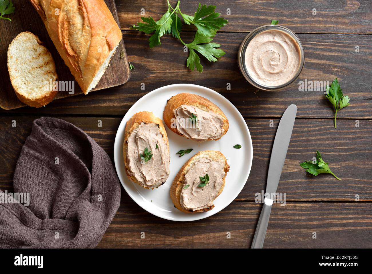 Toasted bread with chicken liver pate over wooden background. Top view ...