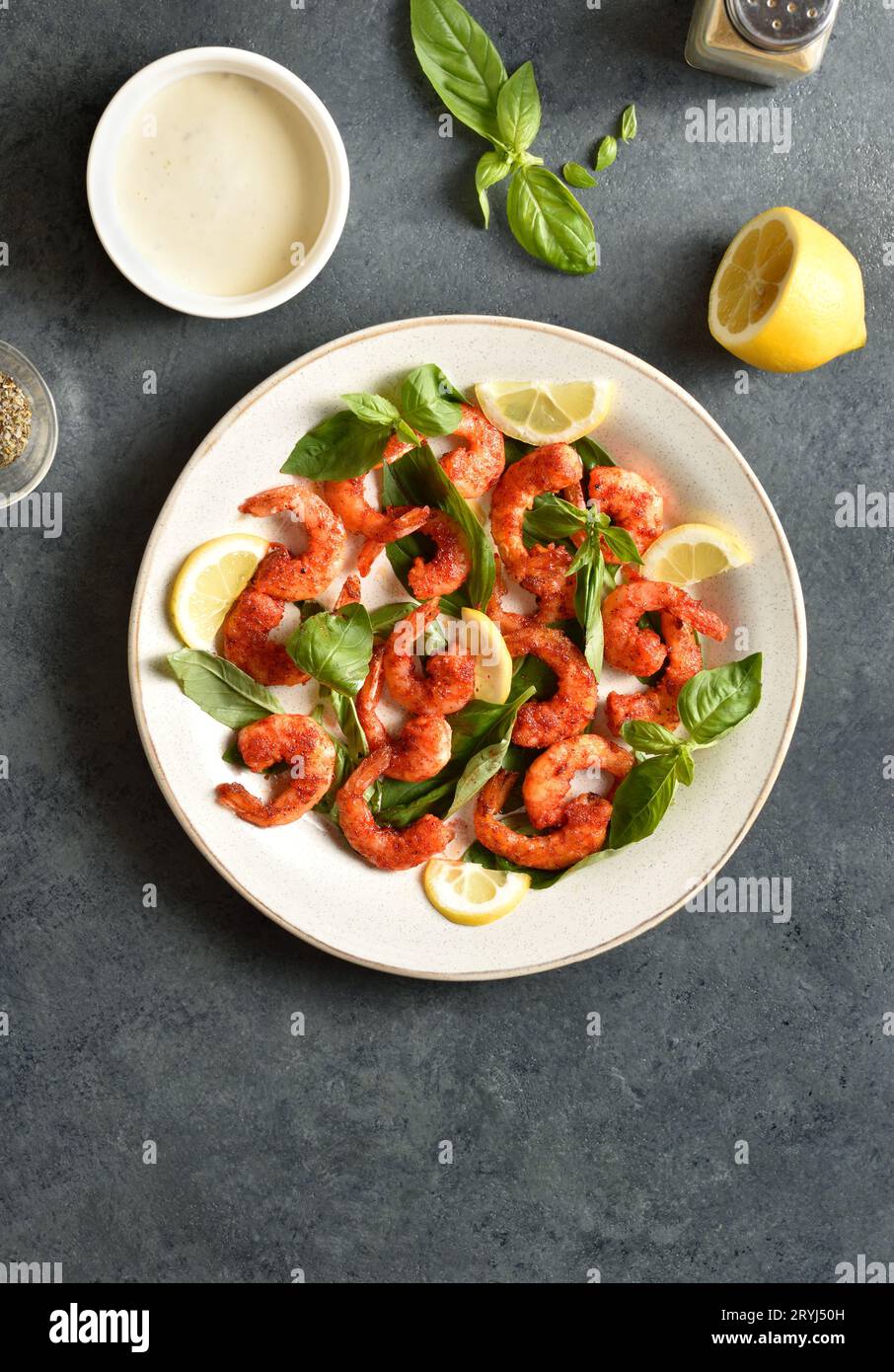 Spicy thai basil shrimp on plate over dark stone background with free ...