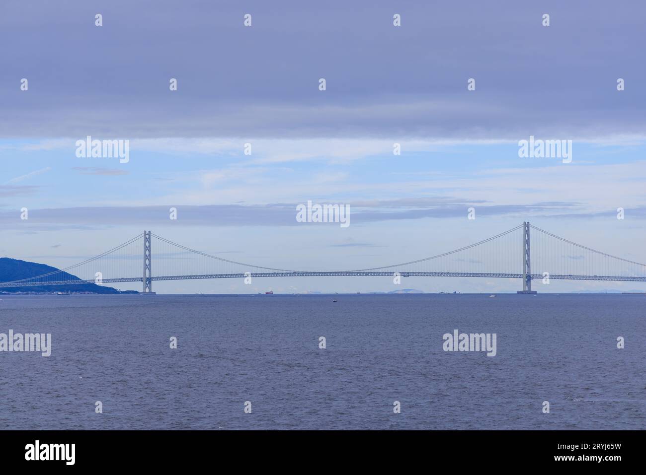 Low cloud layer over Akashi suspension bridge and calm blue water Stock ...
