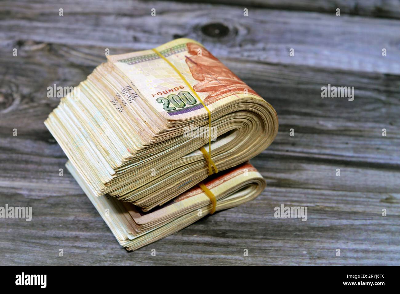 Folded Egyptian money isolated on wooden background, 200 LE two hundred ...