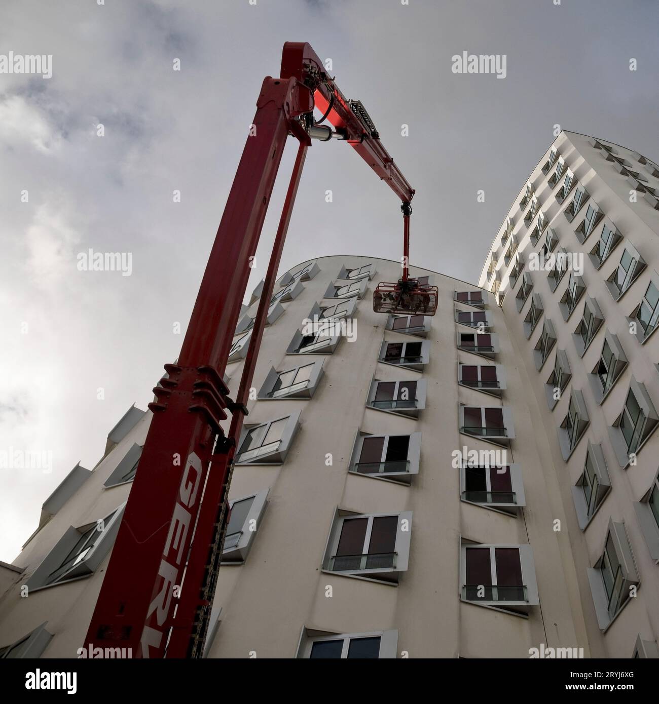 Building cleaners on a work platform with an extended crane at Gehry ...