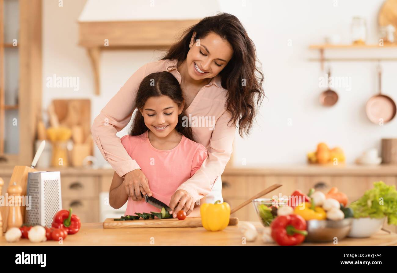 Mom Teaching Kid Girl To Cook Cutting Vegetables At Kitchen Stock Photo ...