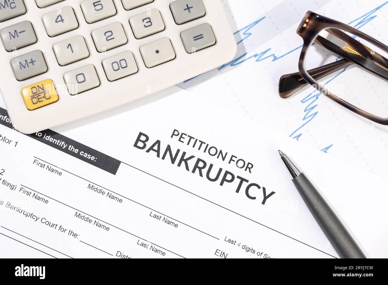 Bankruptcy form, calculator and pen on desk. Personal injury claim form ...