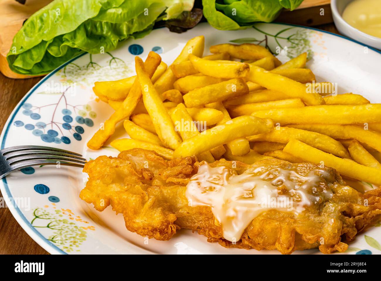 Portion of delicious homemade battered fish and french fried with metal ...