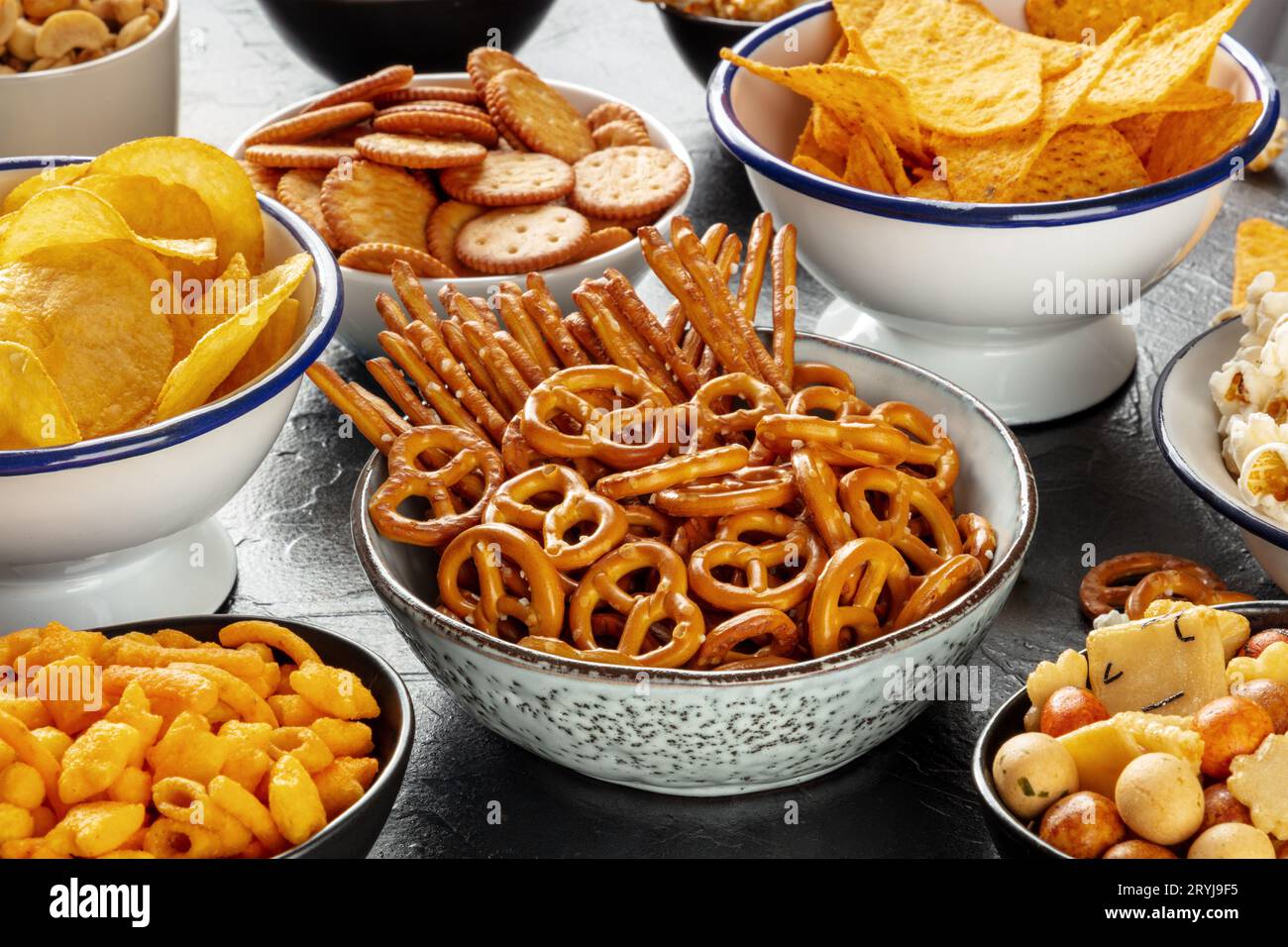Salty snacks, party mix. An assortment of crispy appetizers in bowls ...