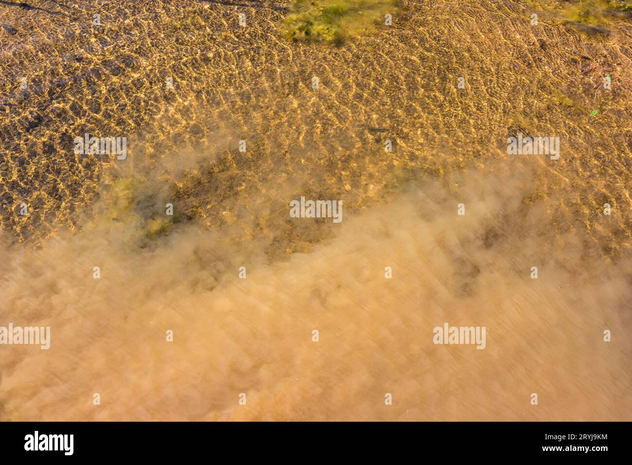 Clean water in a reservoir is covered with silt raised from the bottom ...