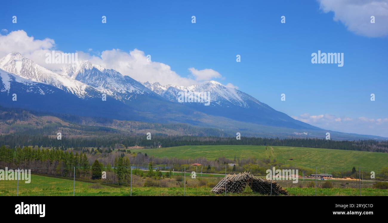 slovakia countryside in spring. snow capped peaks beneath huge white ...
