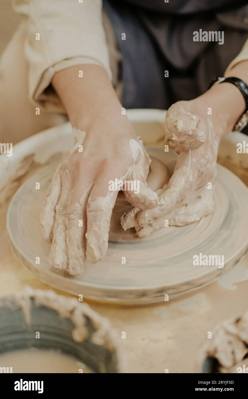 woman sculpts from clay. modeling on a potter's wheel. Hands are molded ...