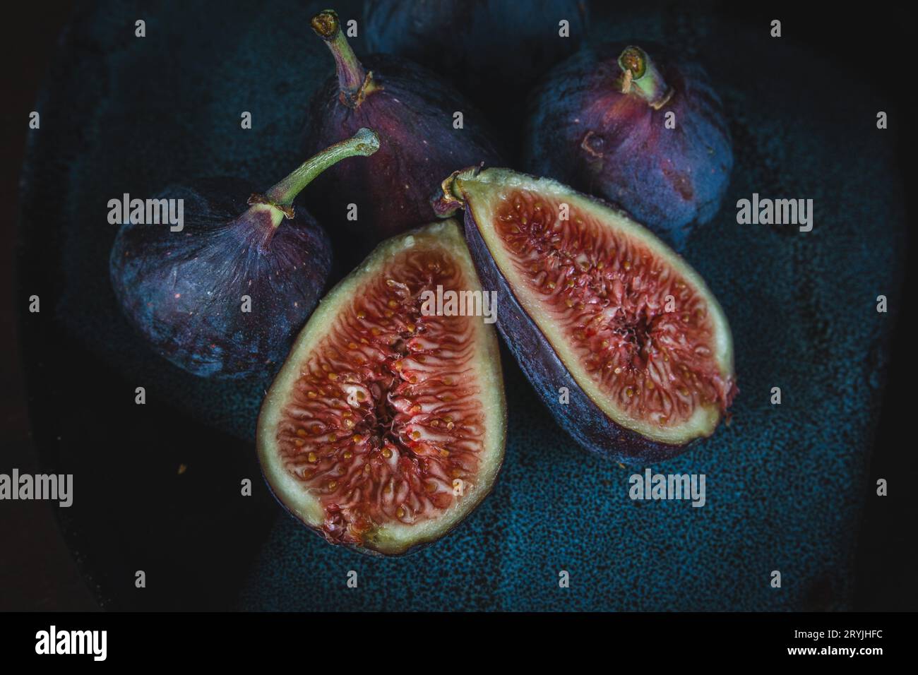 close up photo of fresh fruit figs; cut and ready to serve, three whole ...