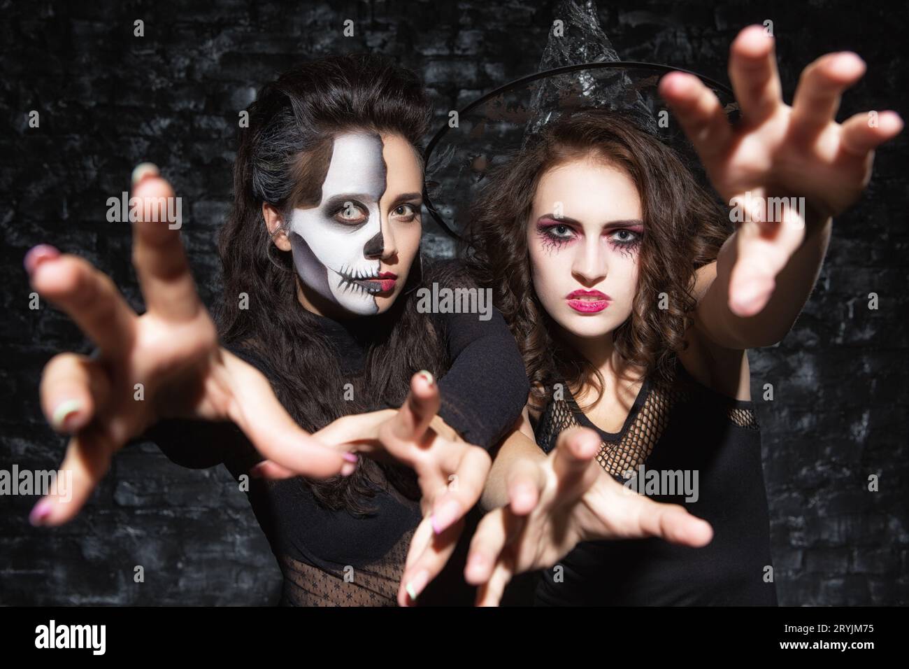 Zombie girls stretching hands toward camera, looking spooky Stock Photo ...