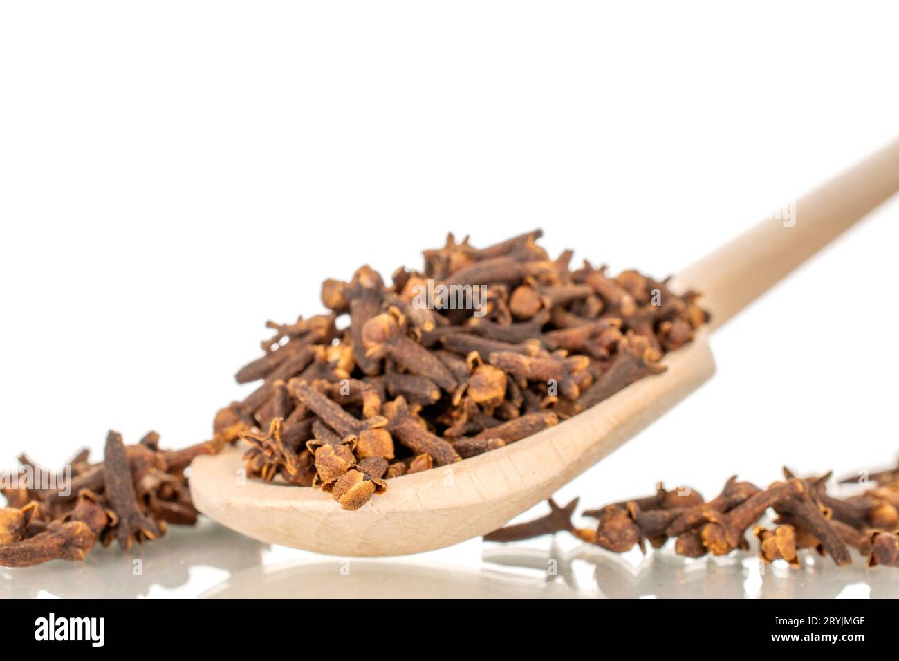 Dry aromatic cloves and with wooden spoon, macro, isolated on white ...