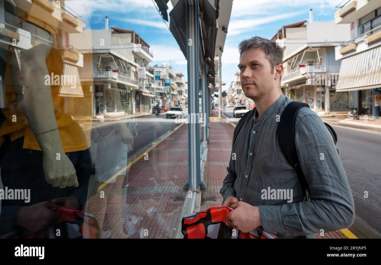 Man looking at the shop window of clothing store Stock Photo - Alamy