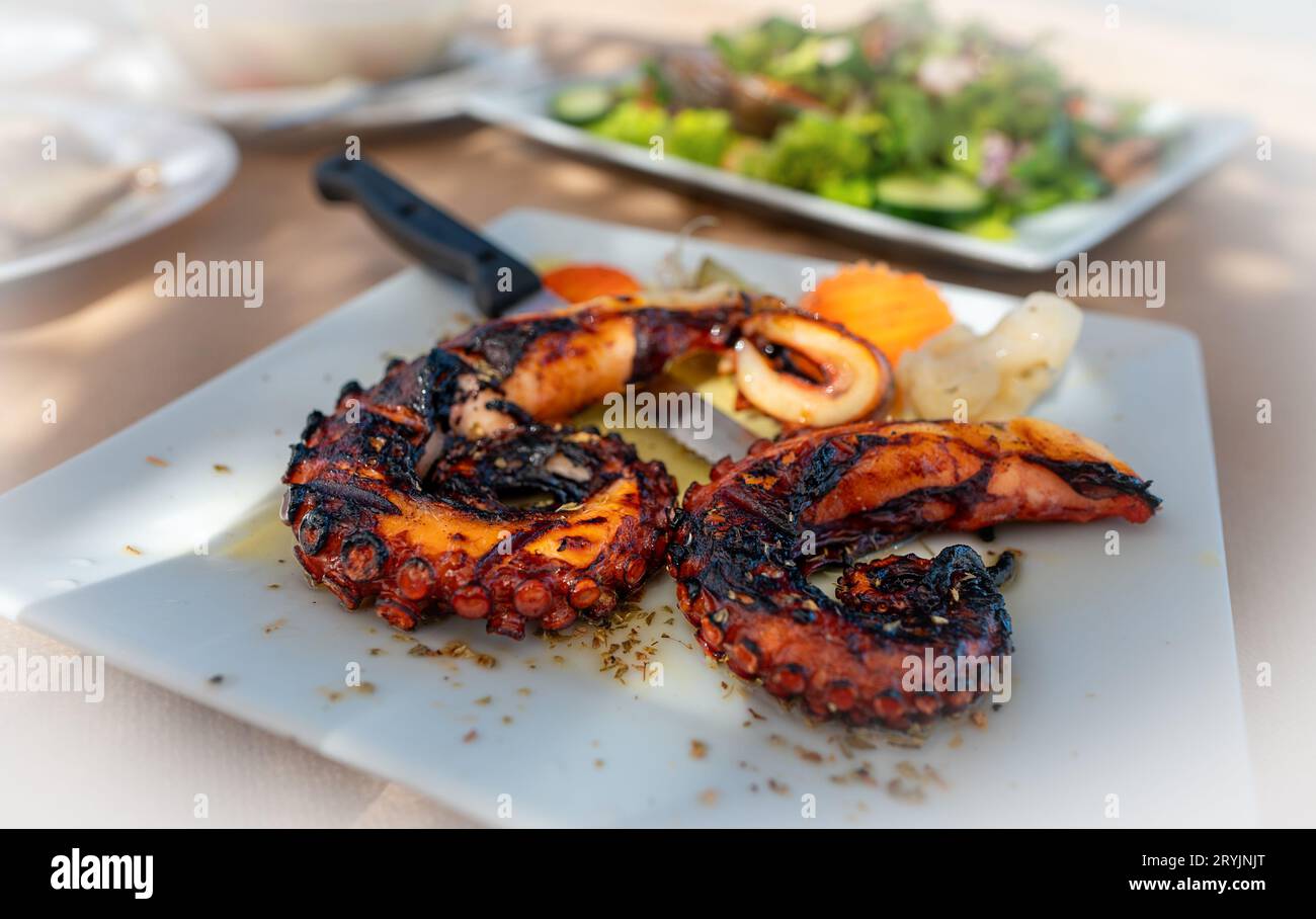 Grilled octopus tentacles seasoned with wine sauce Stock Photo - Alamy