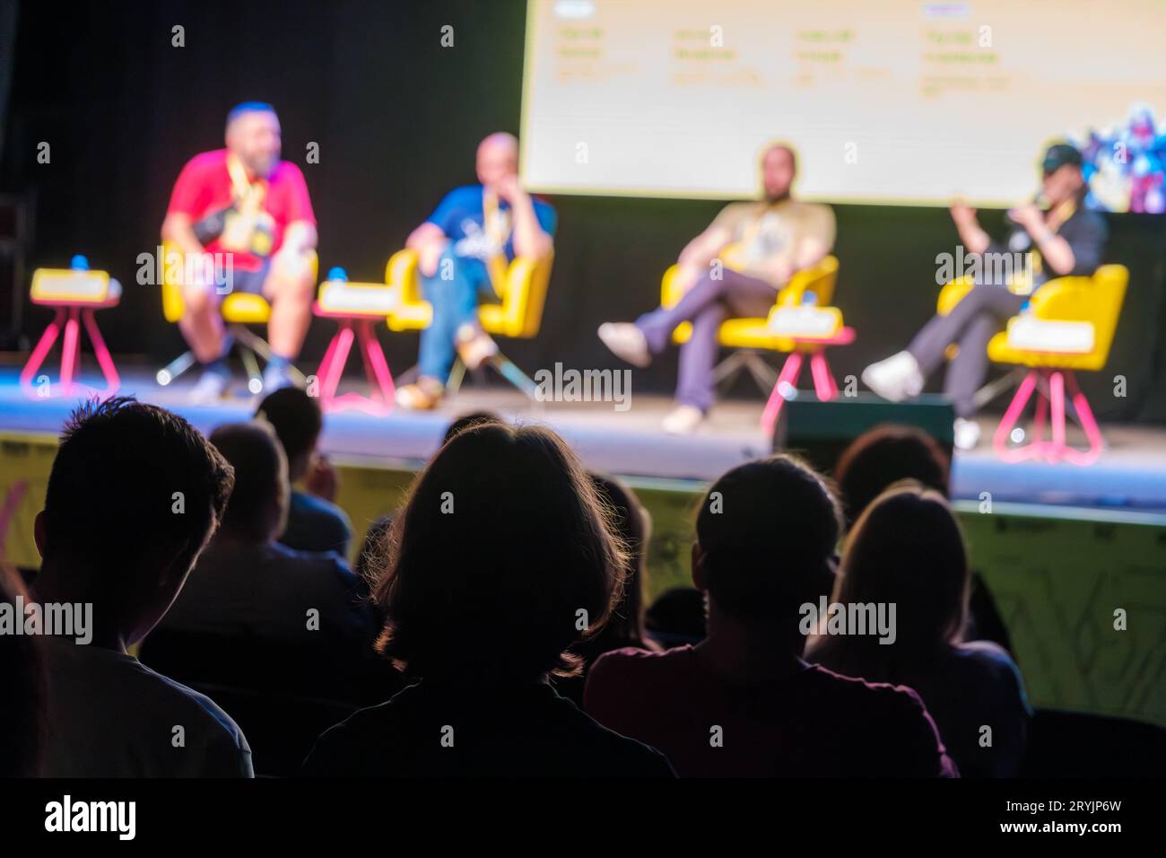 Colleagues sitting on stage during conference answering questions from ...