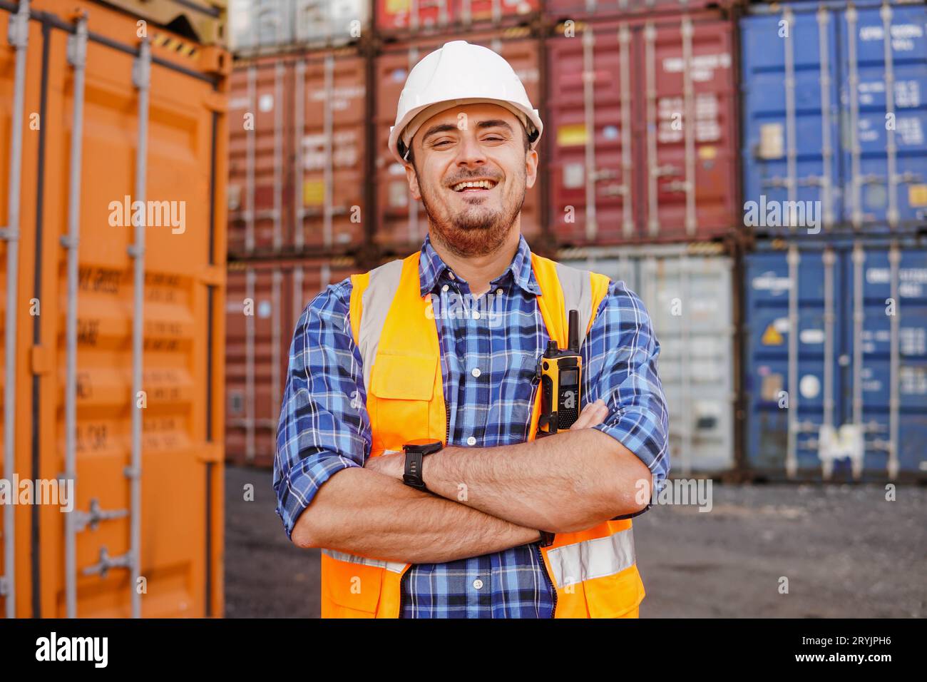 Portrait of smiling container man worker in container warehouse. Import and export shipping ...