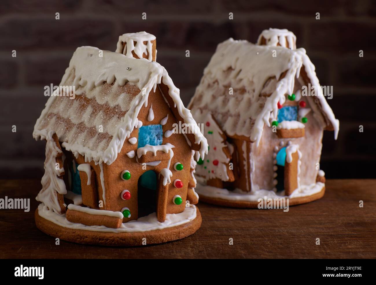 Two Christmas gingerbread houses decorated with sugar icing and ...