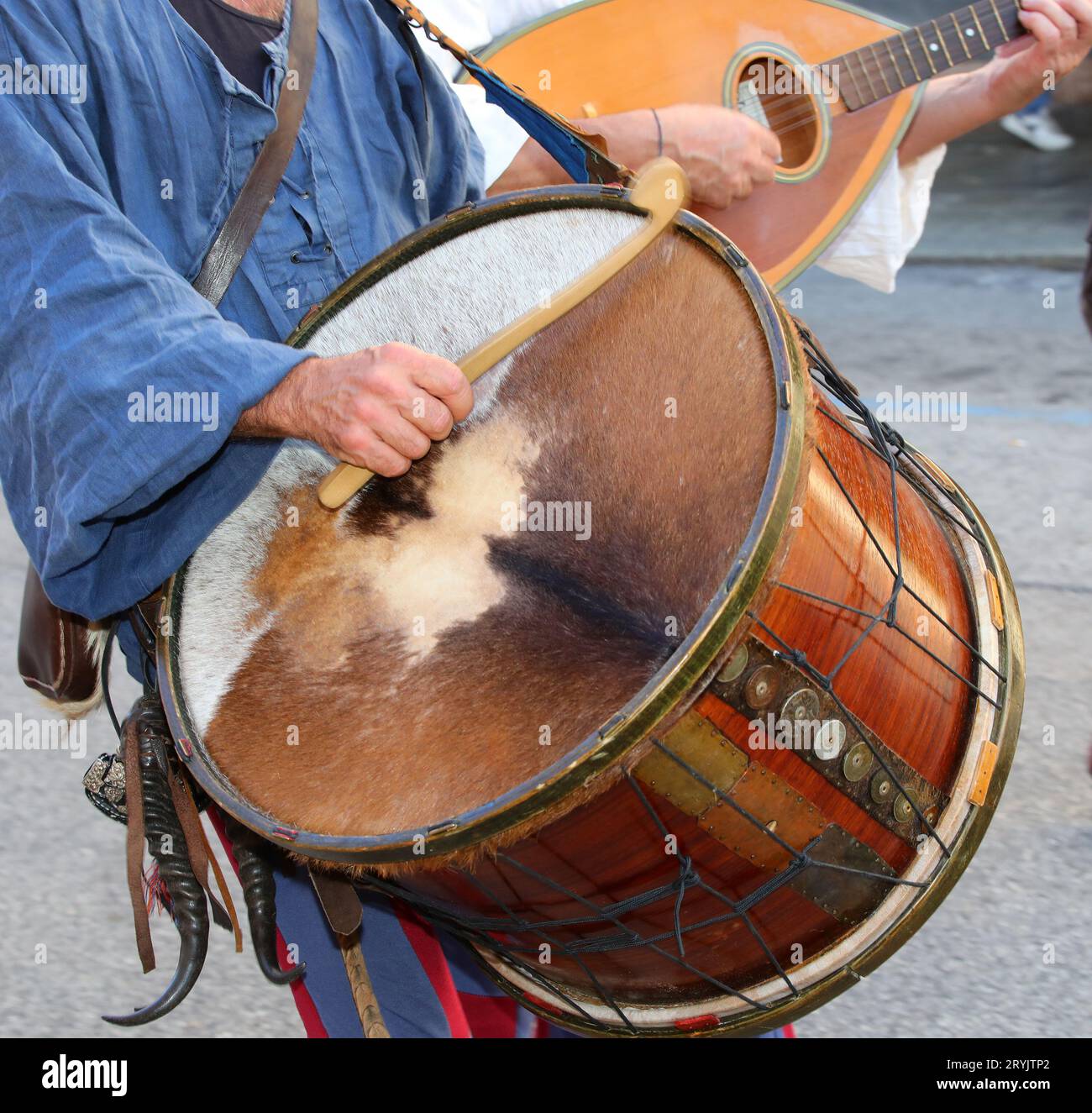 old drummer plays an ancient drum made from animal skins and medieval ...