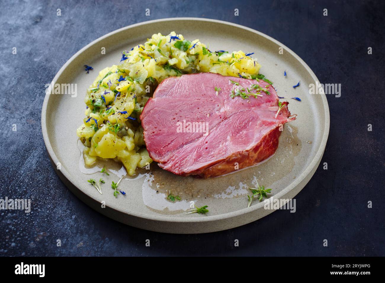 Traditional braised Baden schÃ¤ufele slice served with potato salad as ...