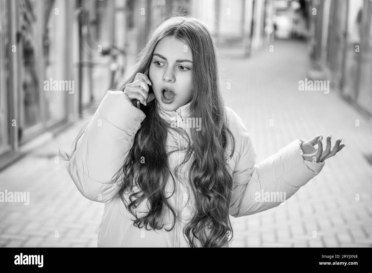 shocked teen girl having phone call in the street. teen girl having ...