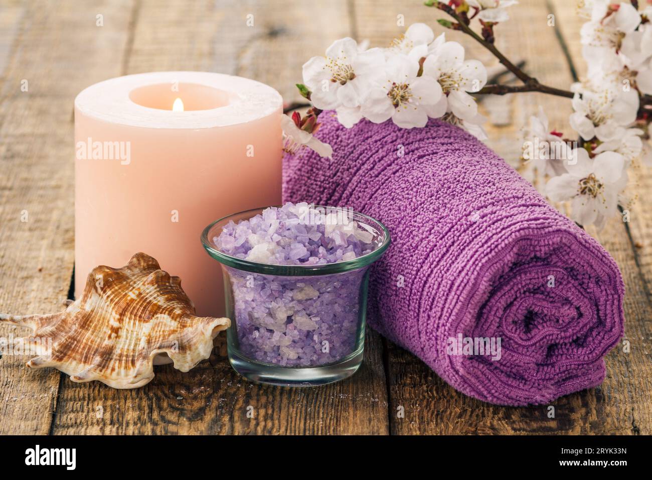Sea salt with the towel, the sea shell and the burning candle with the ...