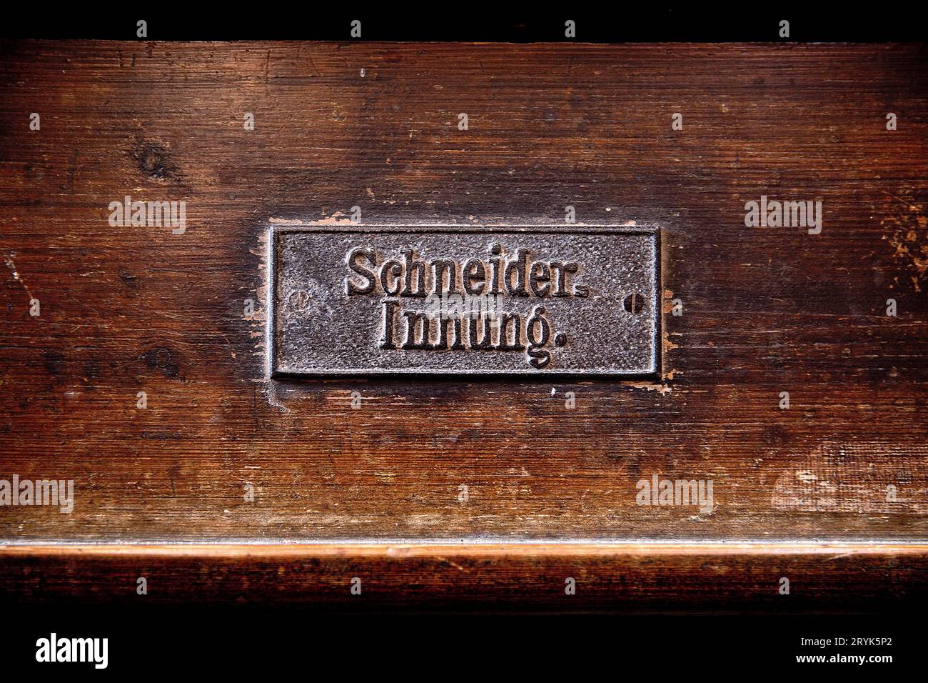 Permanently mounted sign of the tailors' guild on the pew in the ...