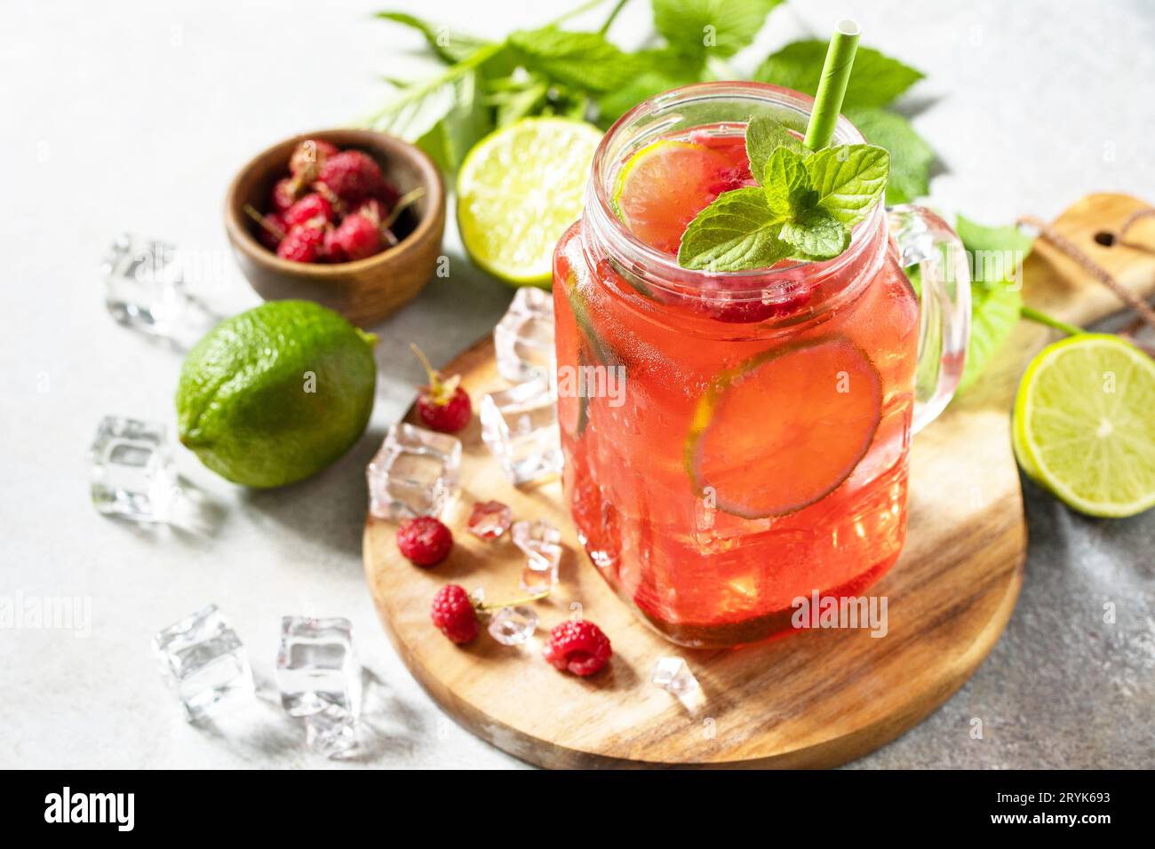 Soft drinks, healthy beverage. Refreshing summer glasses drink raspberry with mint lime and ice ...