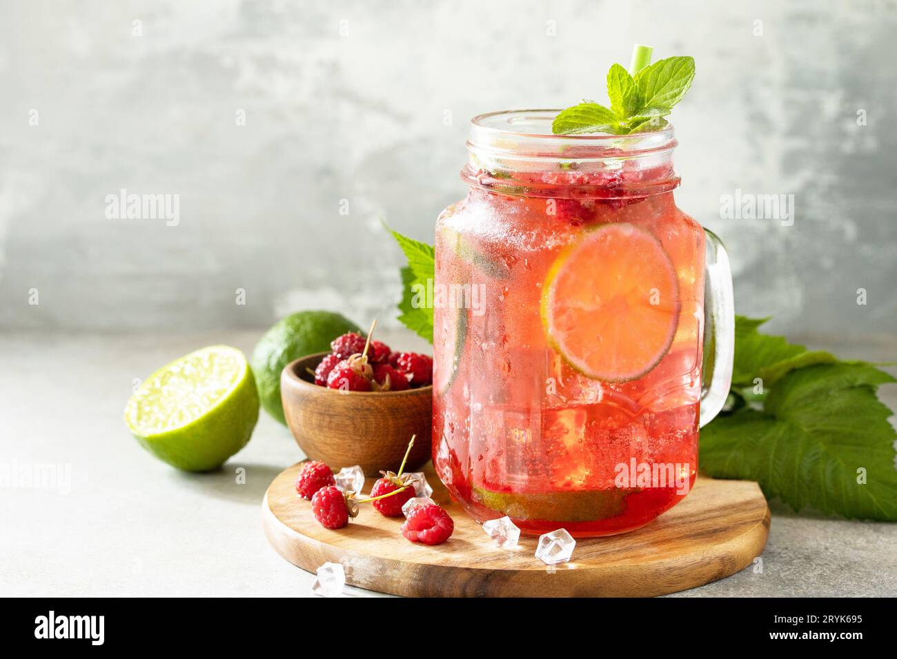 Soft drinks, healthy beverage. Refreshing summer glasses drink raspberry with mint lime and ice ...