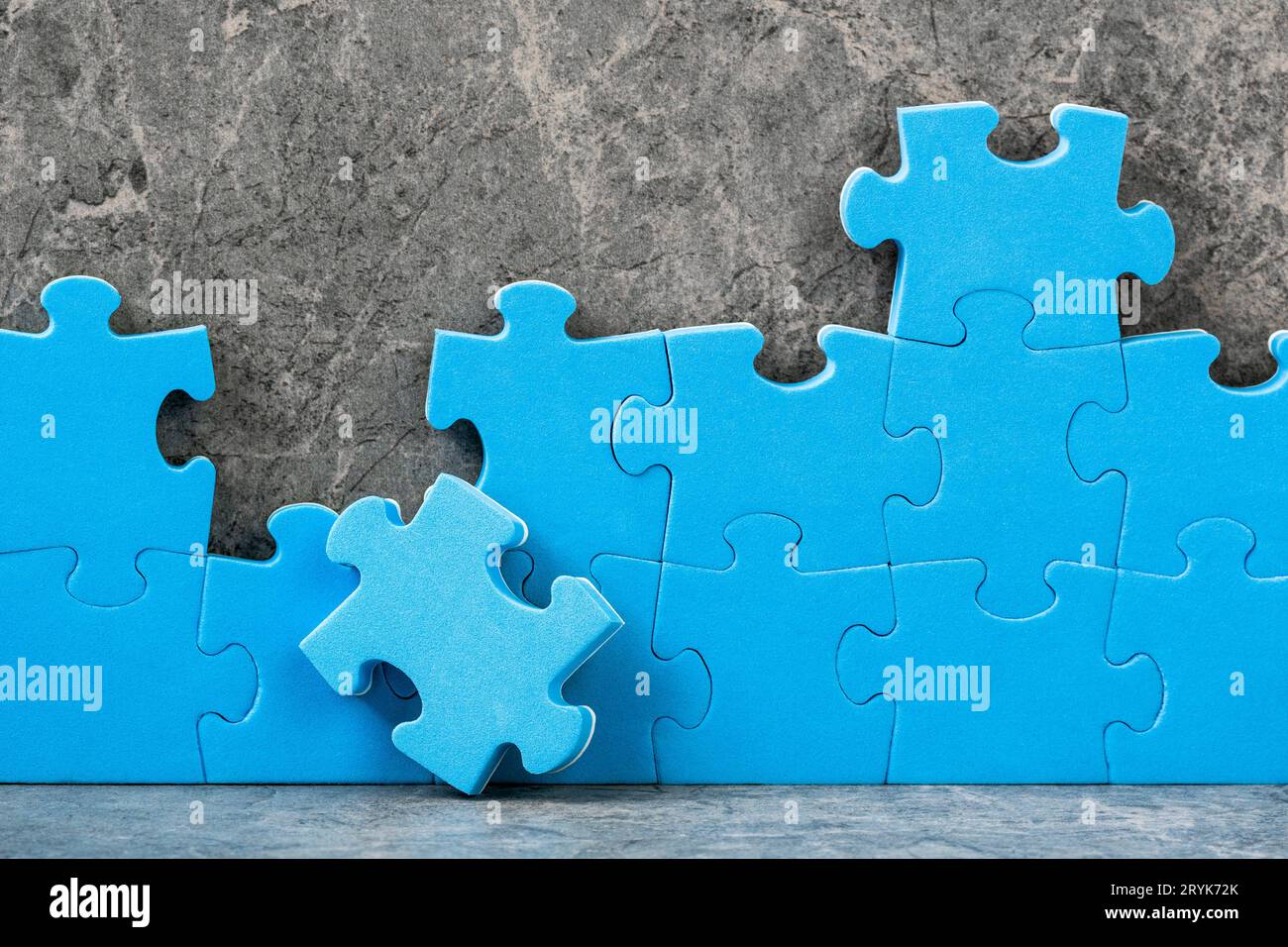 Unfinished blue jigsaw puzzle pieces on grey cement background Stock ...