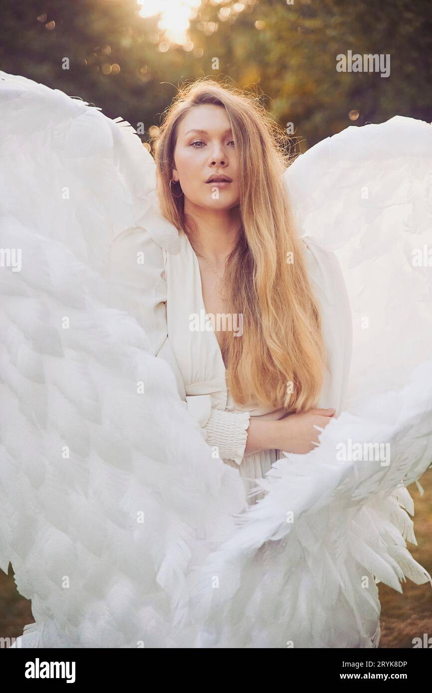 Beautiful girl dressed as an angel in the evening garden Stock Photo ...
