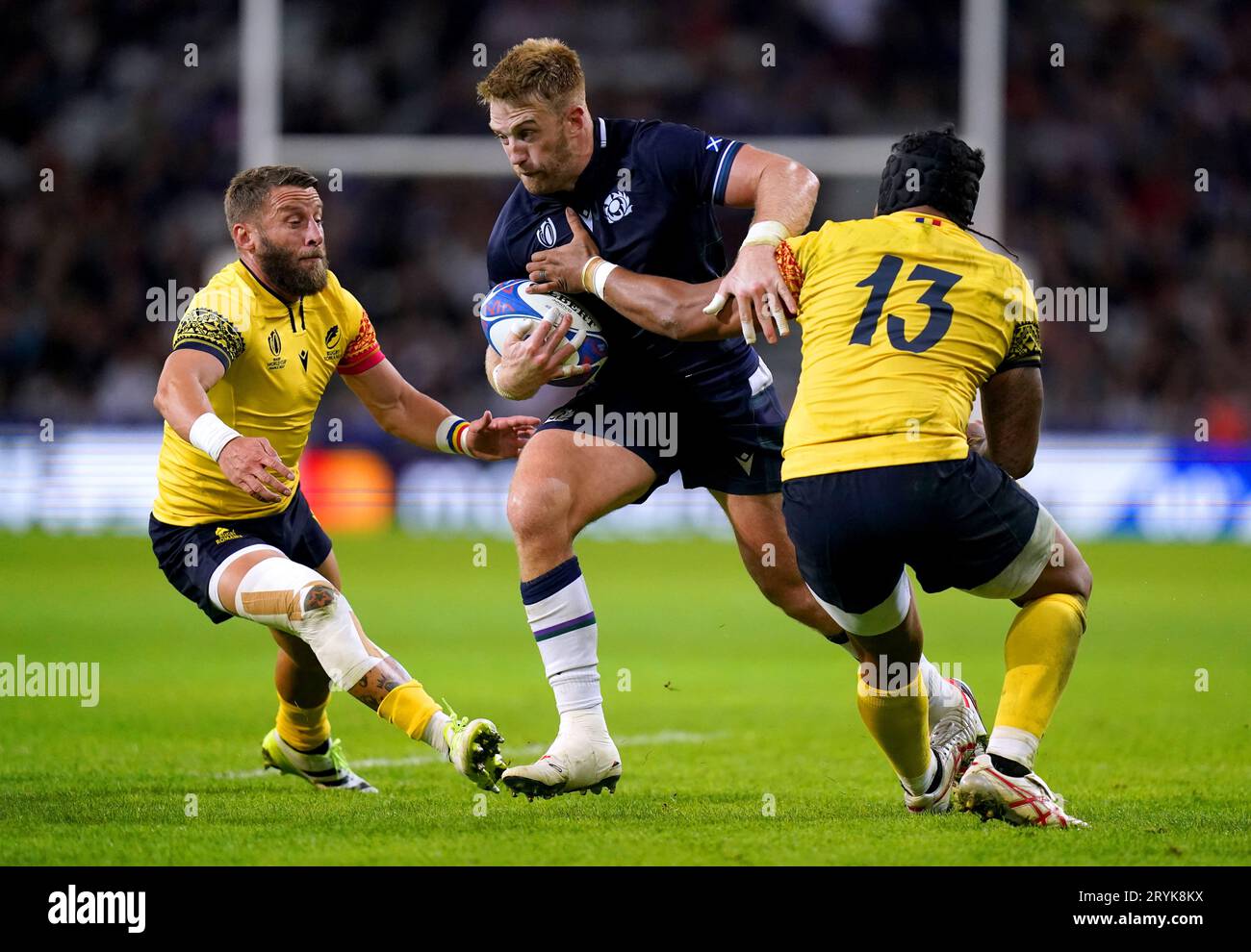 Scotland's Kyle Steyn (centre) is stopped by Romania's Jason Tomane ...