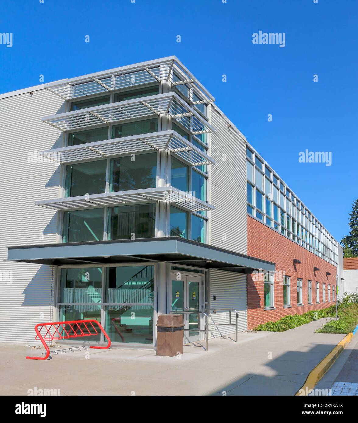 Office building with concrete pathway in front and blue sky background ...