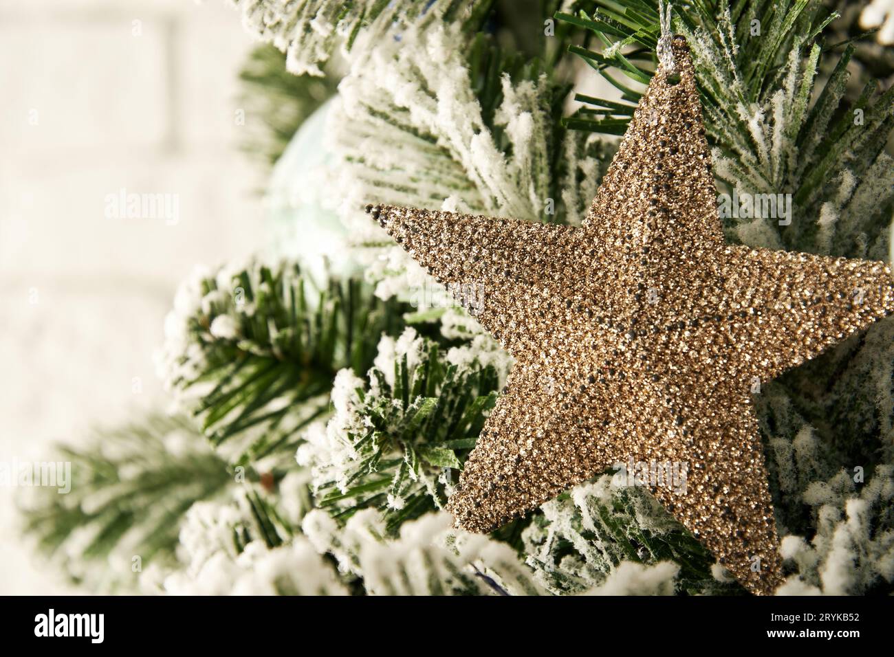 New Years tree branch with big golden star toys in bright sparkles ...