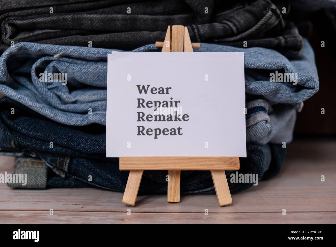 WEAR REPAIR REMAKE REPEAT text on paper note on Jeans clothes ...