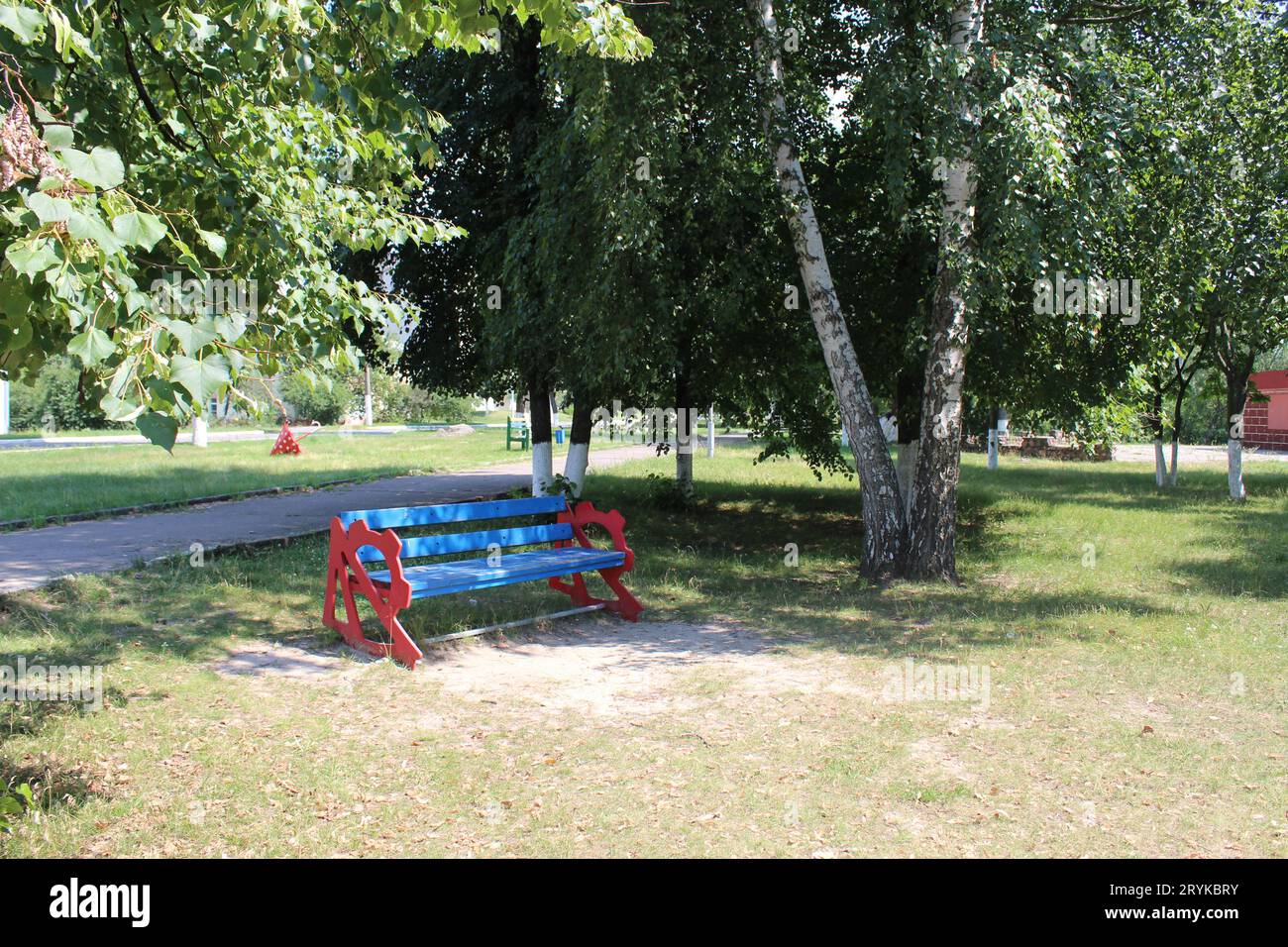 A park bench in the green recreation area. A place to relax near trees ...