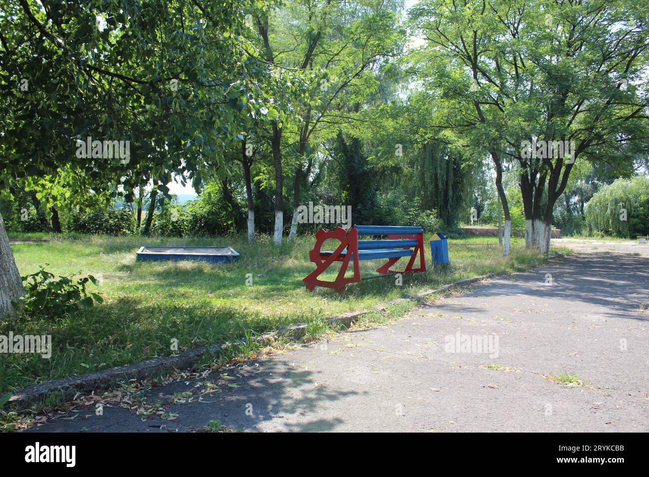 A park bench in the green recreation area. A place to relax near trees ...