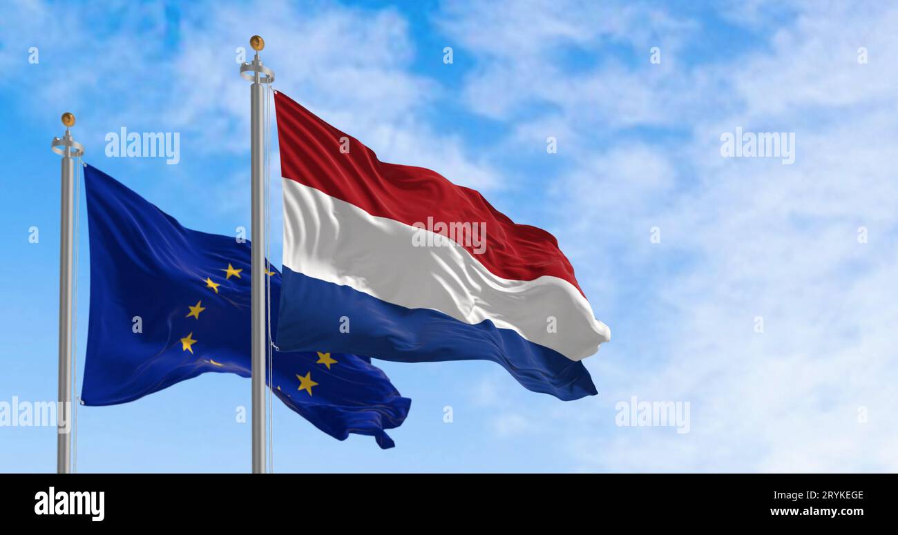 Netherlands and the European Union flags waving in the wind on a clear ...