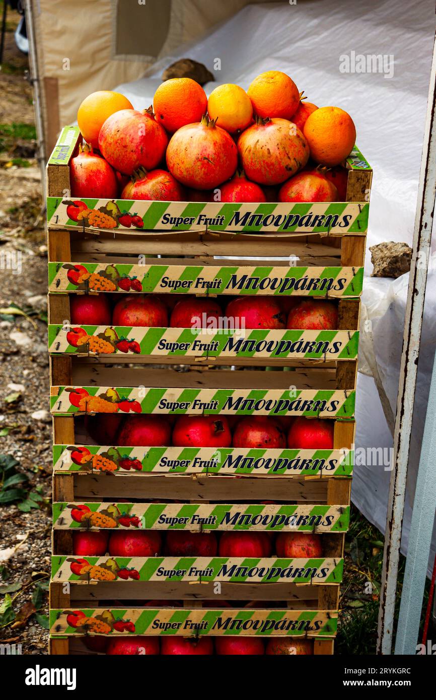 Tower of eight crates of orange and pomegranate. The crates have a ...