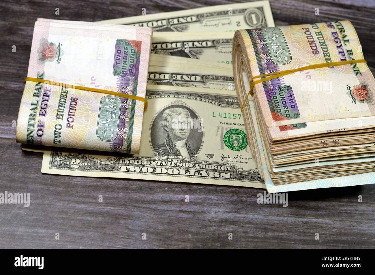 Folded Egyptian money 200 LE and pile of American money isolated on ...