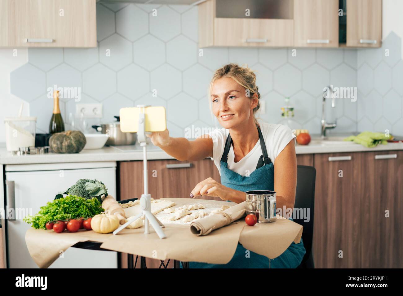 Pretty happy confident woman is cooking in the kitchen and watching a ...