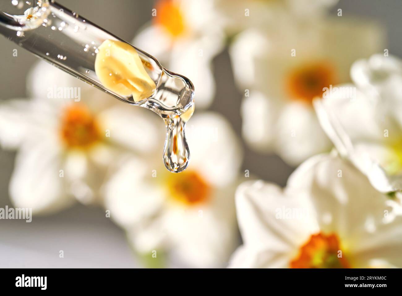 An eyedropper with a cosmetic product on the flower background Stock ...