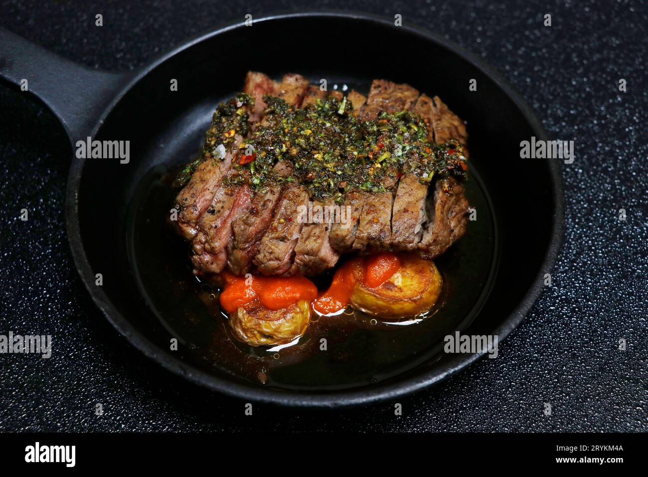 spanish chimichurri beef steaks with potato and spicy brava sauce in ...
